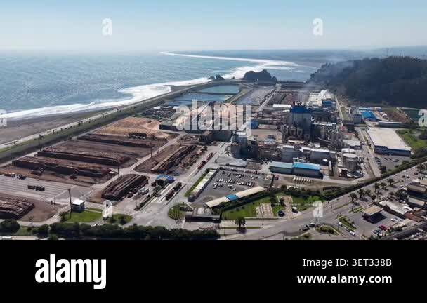 Aerial drone panning shot of Arauco cellulose plant on the coastline of ...
