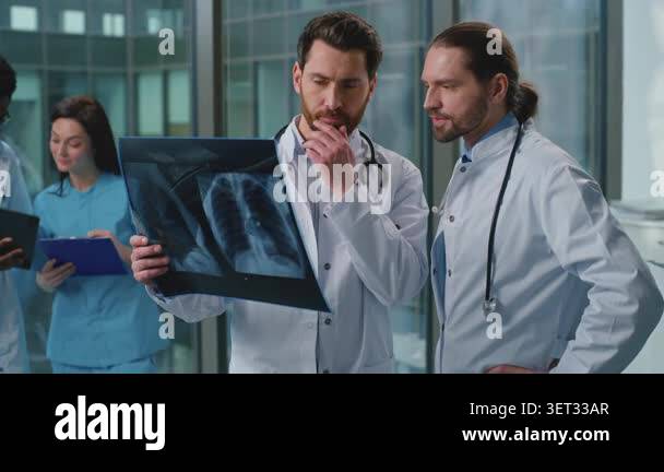Two Caucasian men doctors discussing x-ray of lungs talking males ...