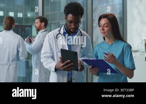 Two diversity doctors man with woman discussing medical examination ...