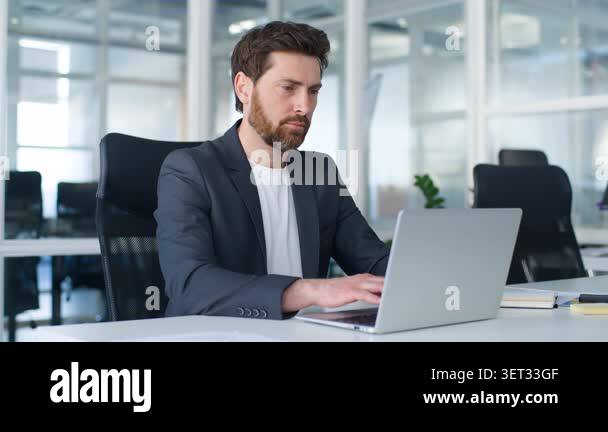 Focused Caucasian middle-aged business man typing laptop thinking ...