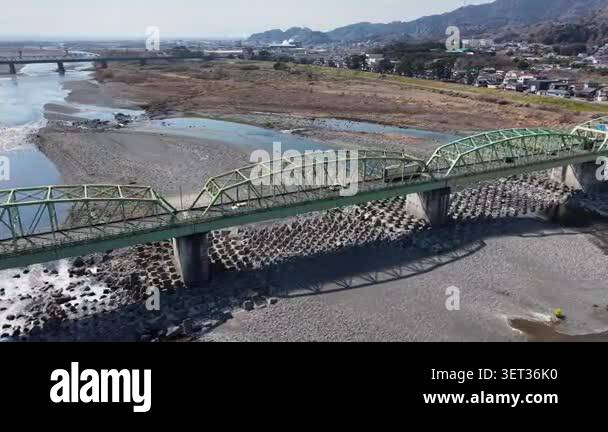 An aerial view of a river, bridges and the surrounding mountains and ...