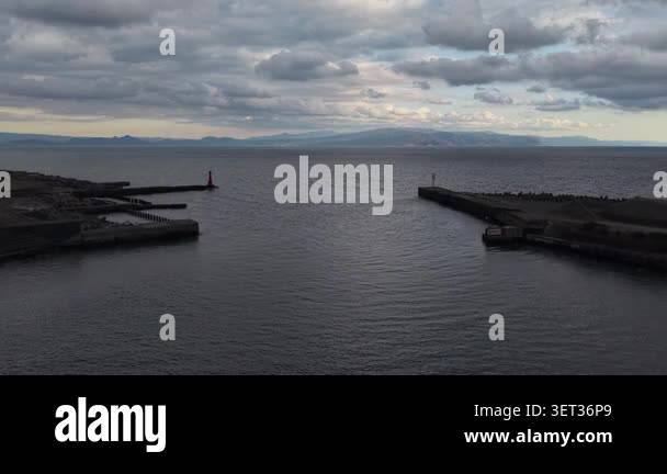 An aerial view of a coastal industrial town, harbour and breakwaters by ...