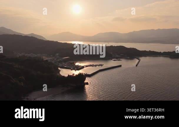 An aerial view of a golden sunset over the calm bay and islands of the ...