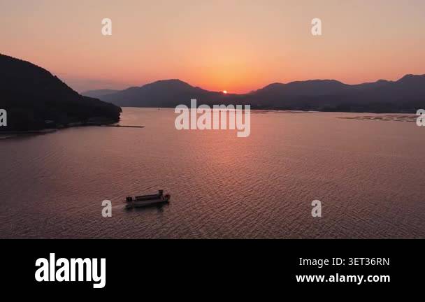 An aerial view of a golden sunset over the calm bay and islands of the ...
