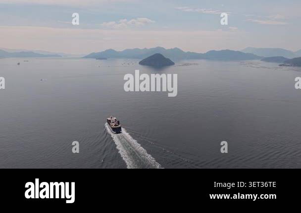 An aerial view of a boat crossing the calm hazy Seto Inland Sea between ...