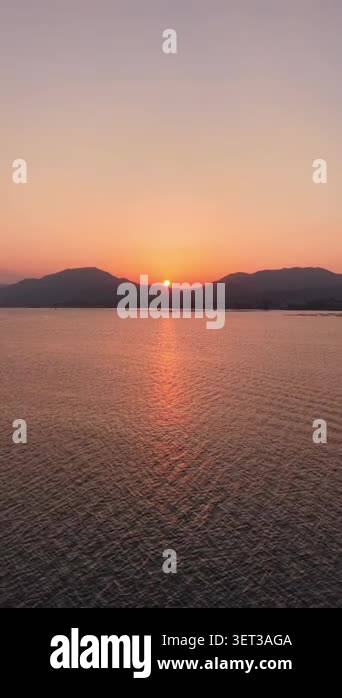 An aerial view of a golden sunset over the calm bay and islands of the ...