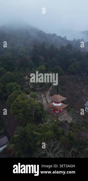 An aerial view of a misty island coastline, forested mountains and the ...