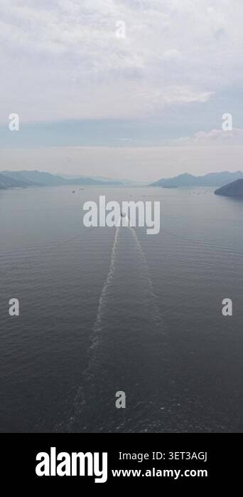 An aerial view of a boat crossing the calm hazy Seto Inland Sea between ...