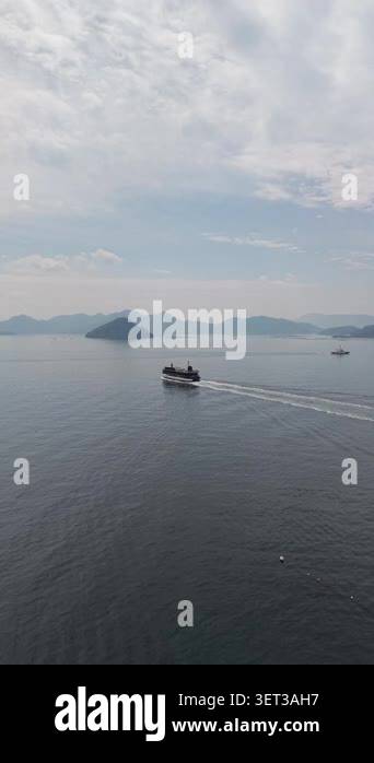 An aerial view of a boat crossing the calm hazy Seto Inland Sea between ...