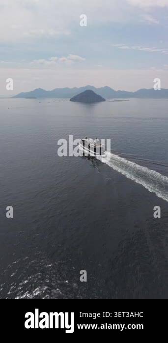 An aerial view of a boat crossing the calm hazy Seto Inland Sea between ...