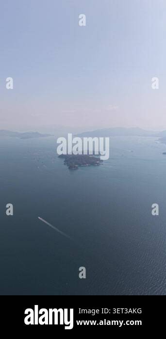 An aerial view of a misty island coastline, forested mountains and the ...