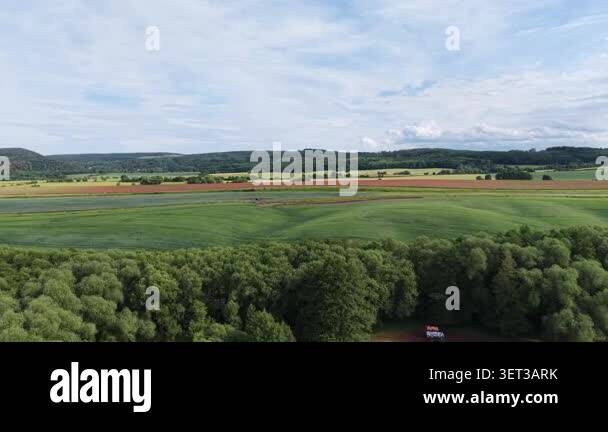 An aerial view of green rolling fields, meadows and forested hills of ...