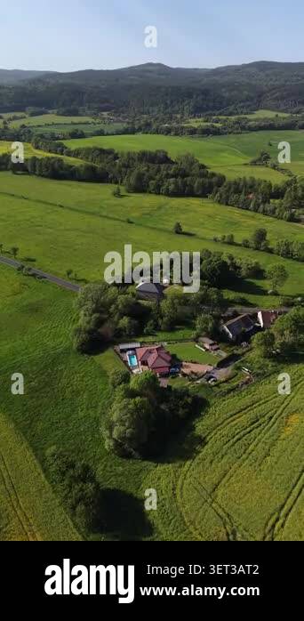 An aerial view of green rolling fields, meadows and forested hills of ...
