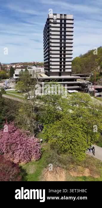 An aerial view of a modern spa hotel tower above the wooded valley of ...