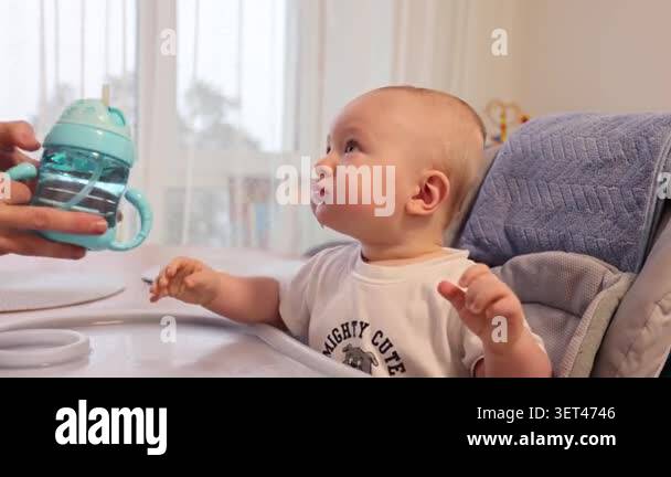 Baby becomes angry and showing fists because mother does not let him to ...