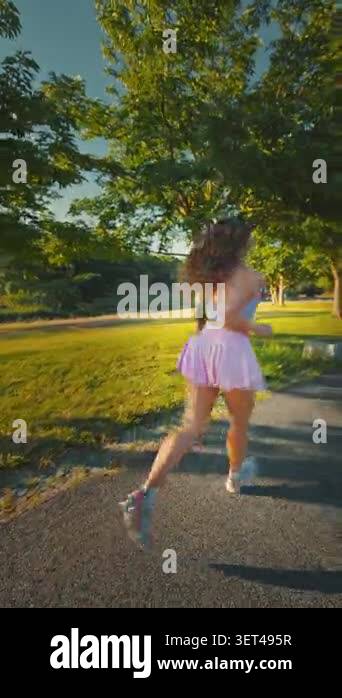 Active young woman jogging on a path in a park, maintaining a healthy ...