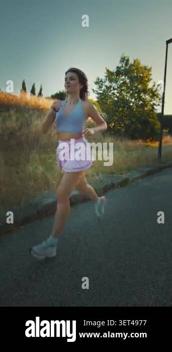 Young athletic woman jogging on a country road during a beautiful ...