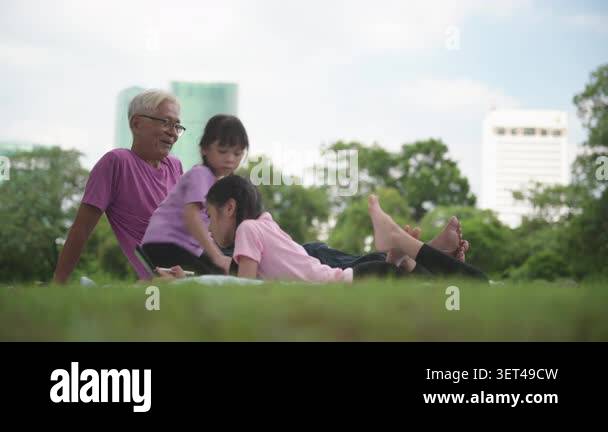 Happy Asian family children using tablet with her grandfather in the ...