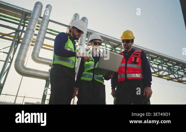 Engineers and industrial inspectors reviewing technical data and ...