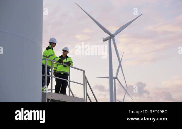 Windmill engineers inspect and discuss operations at a wind turbine ...