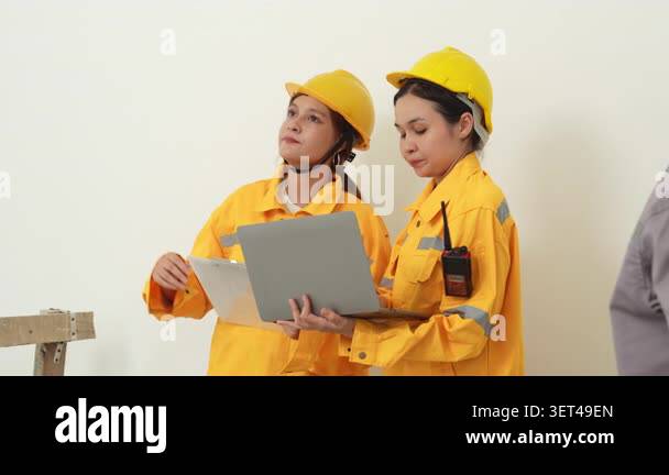 Female construction inspectors wearing safety helmets reviewing ...