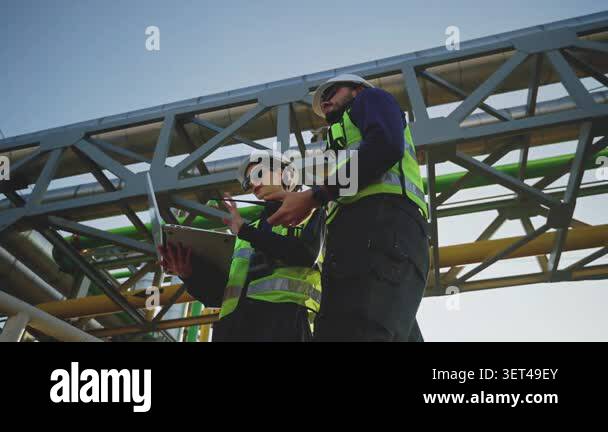 Engineers and industrial inspectors reviewing technical data and ...