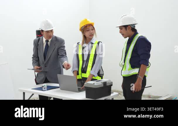 Professional construction team and building inspector looking laptop ...