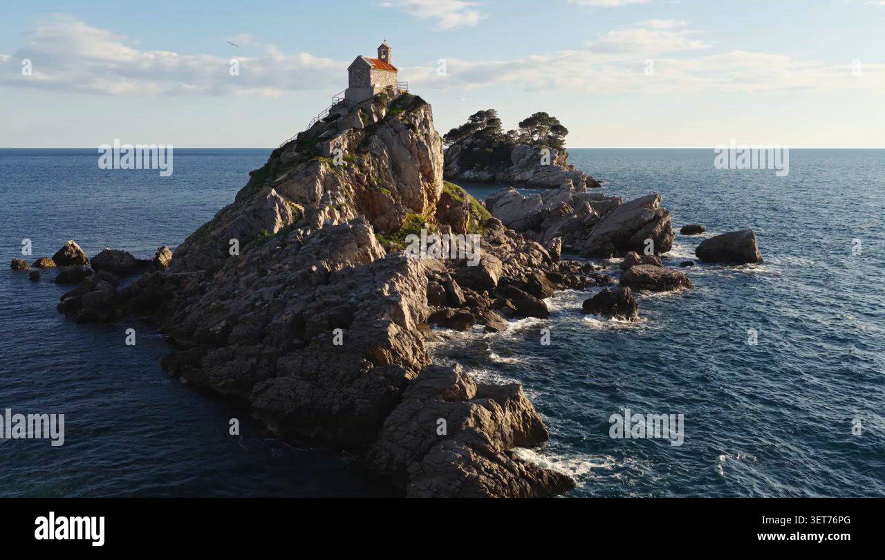 Rocky Island With a Small church on Top in the sea, flock of seagulls ...