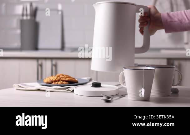 Pure water boils in an electric kettle on the table in the kitchen ...