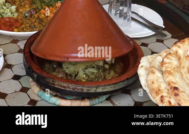 Traditional Moroccan tagine with meat, vegetables, onions, olives, and ...