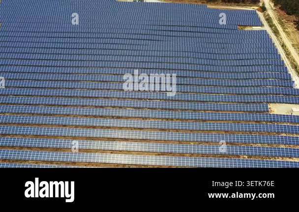 Aerial drone perspective of blue solar panels arranged in rows on field ...