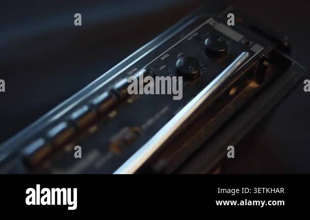 Close-up view of a dark audio control panel with rows of knobs and ...