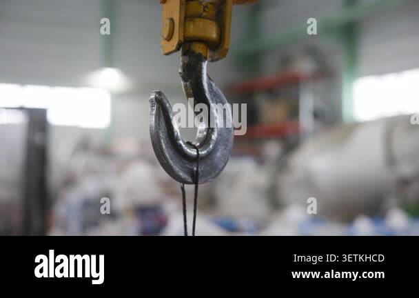 Heavy steel lifting hook hanging in an industrial workshop. High ...