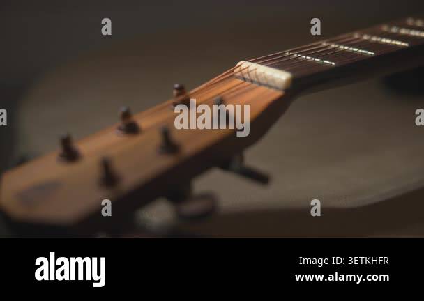 Close-up of a guitar headstock and neck with tuning pegs, angled ...