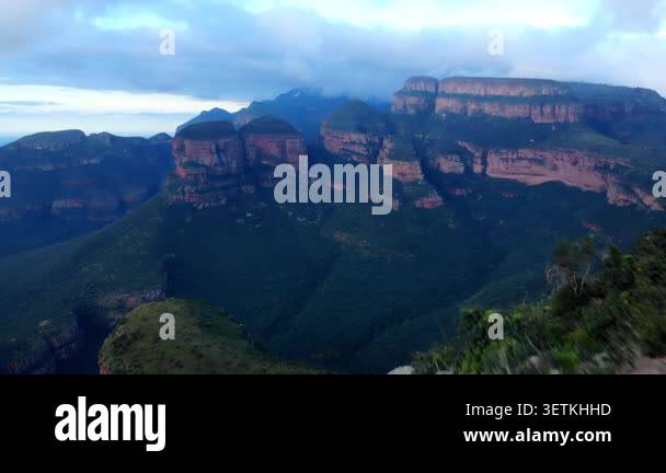 Wide panoramic view of a rugged mountain landscape with layered cliffs ...