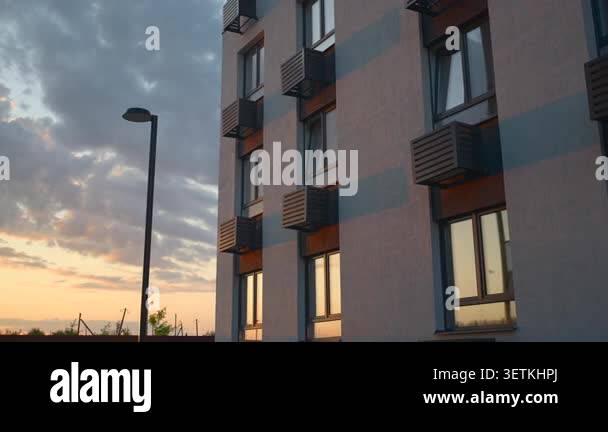 A modern apartment building on the right side of the frame stays ...