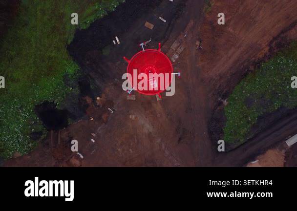 Top down aerial view of a bright red circular communications tower ...