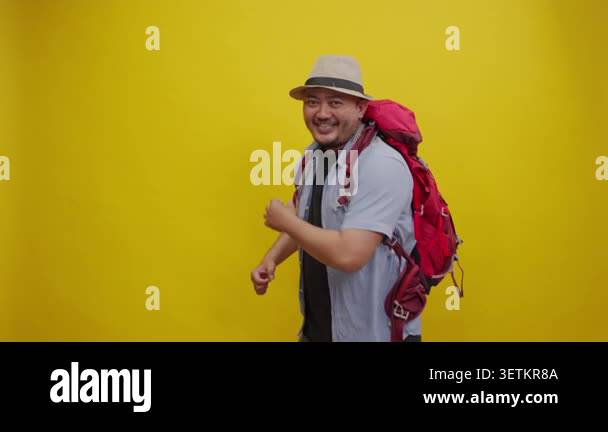 Happy Backpacker Dancing with Excitement, Isolated on a Yellow ...