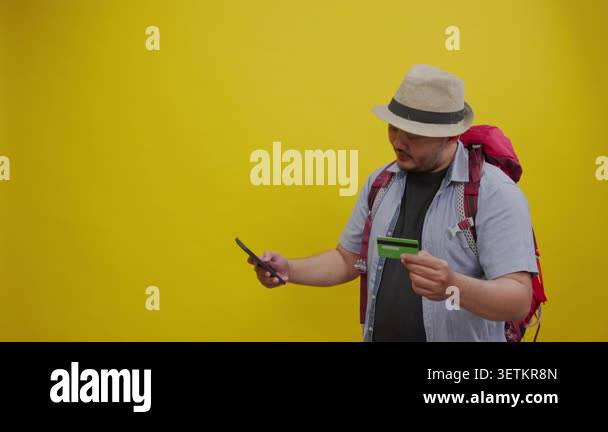 Asian Tourist Making a Mobile Payment with a Credit Card and Smartphone ...