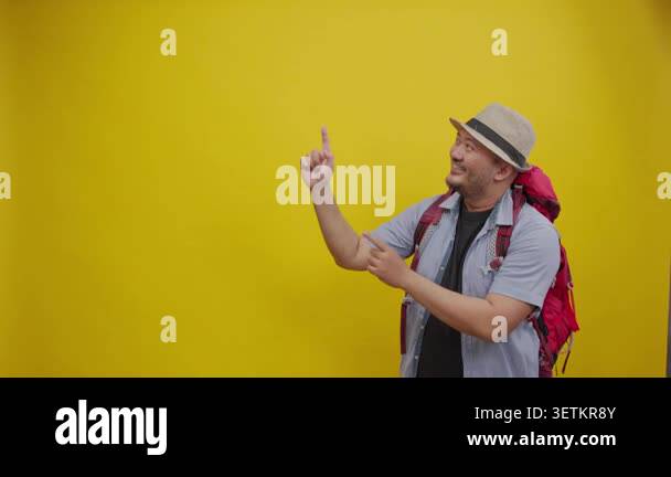 Smiling Backpacker Wearing a Hat and Red Backpack Pointing Up Toward ...