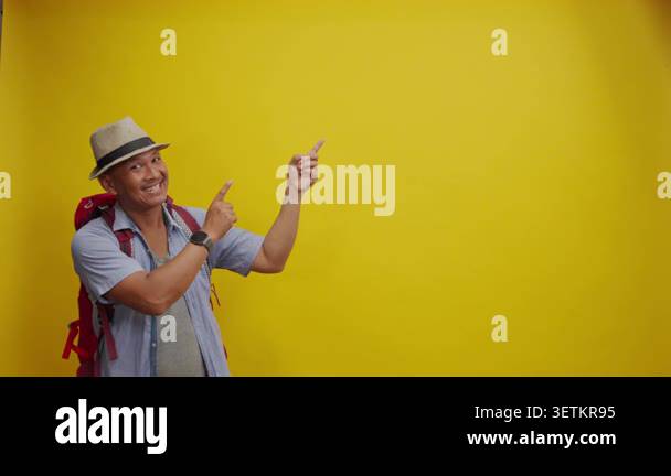 Male Traveler Wearing a Red Backpack and Straw Hat Pointing Toward ...