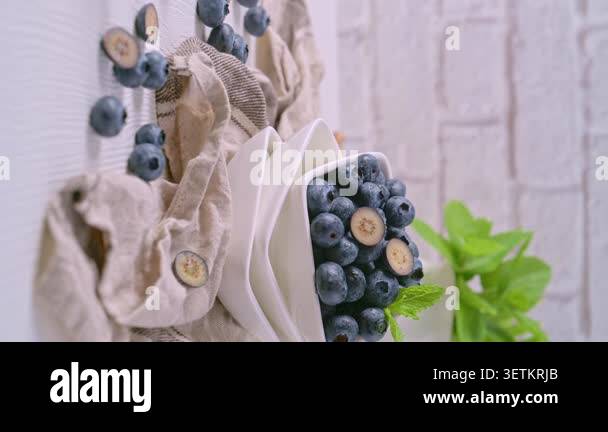 A studio close-up of a white square bowl filled with plump, fresh ...