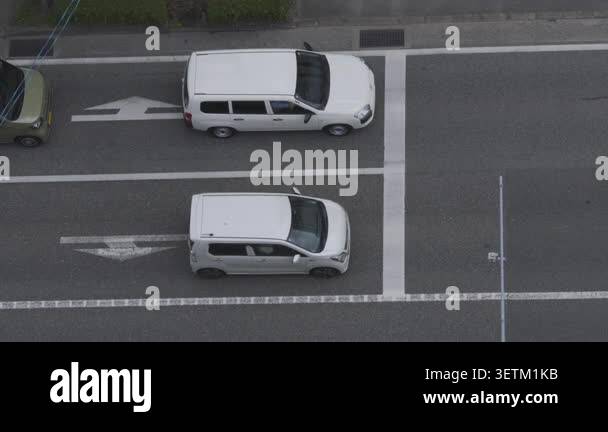 Top down view of cars driving on a city street with road arrows ...