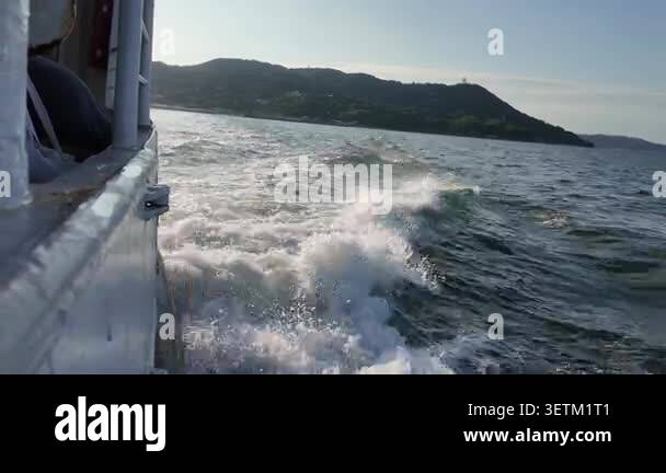 High angle onboard view looking down at the white sea foam and waves ...