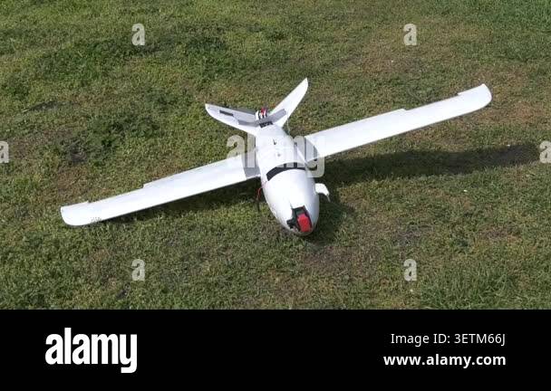Medium-range aircraft-type strike drone resting on grass before launch ...