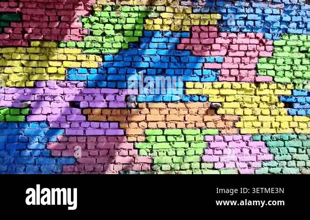 A vibrant brick wall painted in a patchwork of bright colorsblue, pink ...