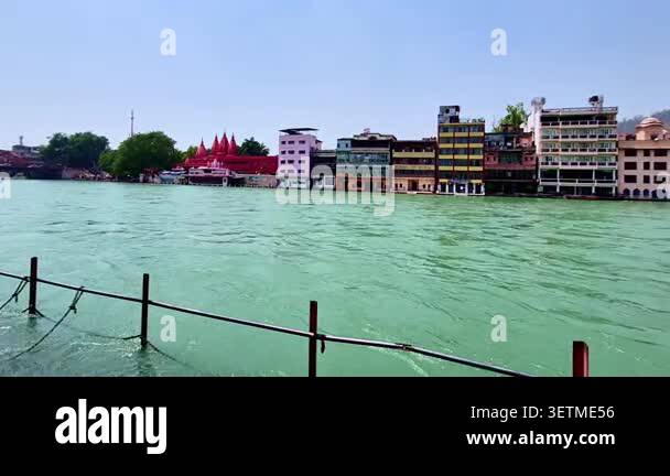 The fast-flowing, pale green waters of the Ganges River stretch across ...