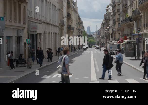 PARIS, FRANCE, JUNE 4, 2026 Pedestrians walk along sidewalks and cross ...