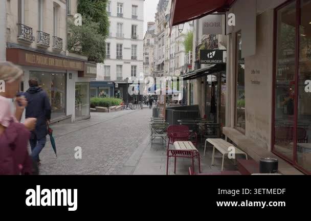 PARIS, FRANCE, JUNE 4, 2026 Pedestrians walk down a cobblestone ...