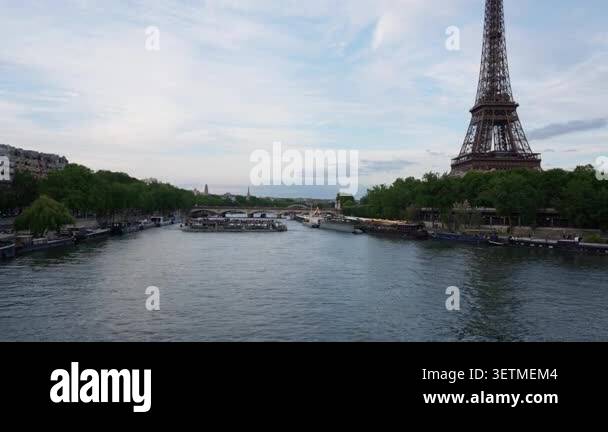 Tourists on a passenger cruise boat navigate the Seine River past the ...